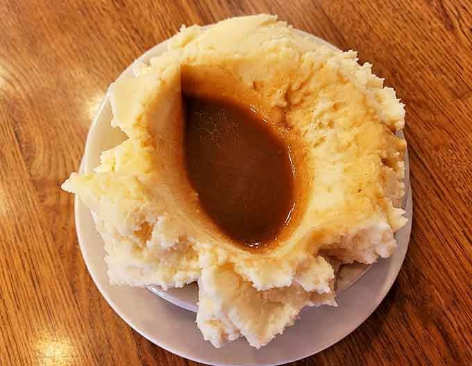 These aren't just mashed potatoes &ndash; they're fluffy clouds with a gravy crater deep enough to solve all life's problems temporarily.