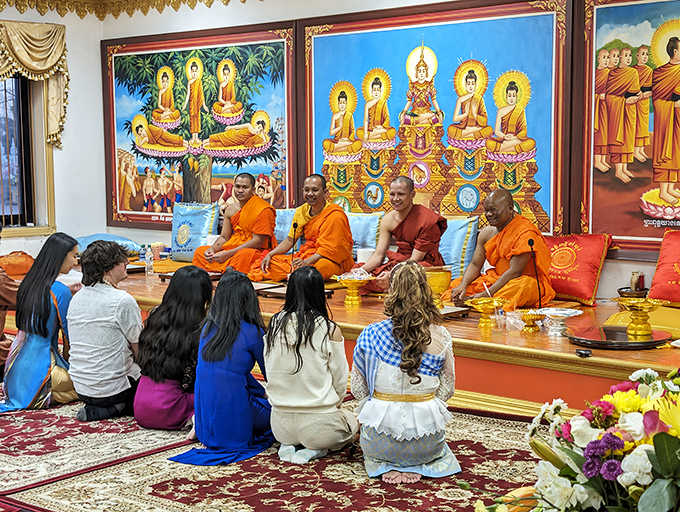 Cultural transmission in action—monks share Buddhist teachings with visitors, creating bridges of understanding that span continents and generations.