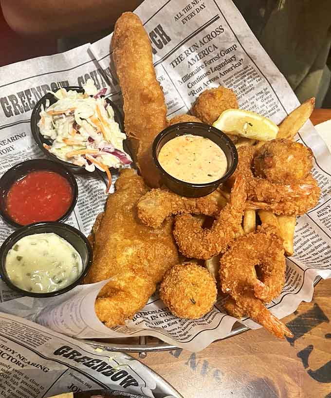 This seafood feast arrives like edible artwork on newspaper – crispy, golden treasures from the deep that make sharing seem like a terrible idea.