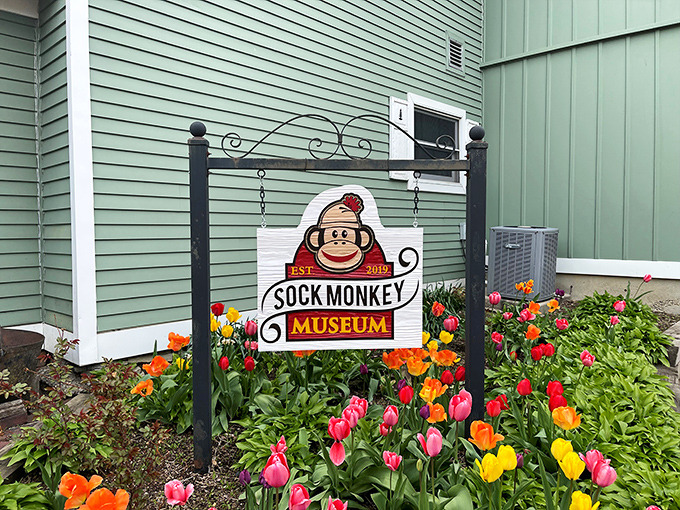 Nestled among colorful spring blooms, the museum's sign invites curious travelers to discover the world of sock monkeys.