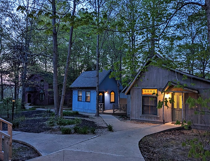 As darkness falls, the cottages glow with welcoming light, creating a magical woodland village atmosphere throughout the property.