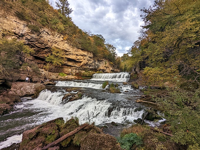 The park's dramatic rock formations frame the cascading water, revealing millions of years of geological history in their layered faces.