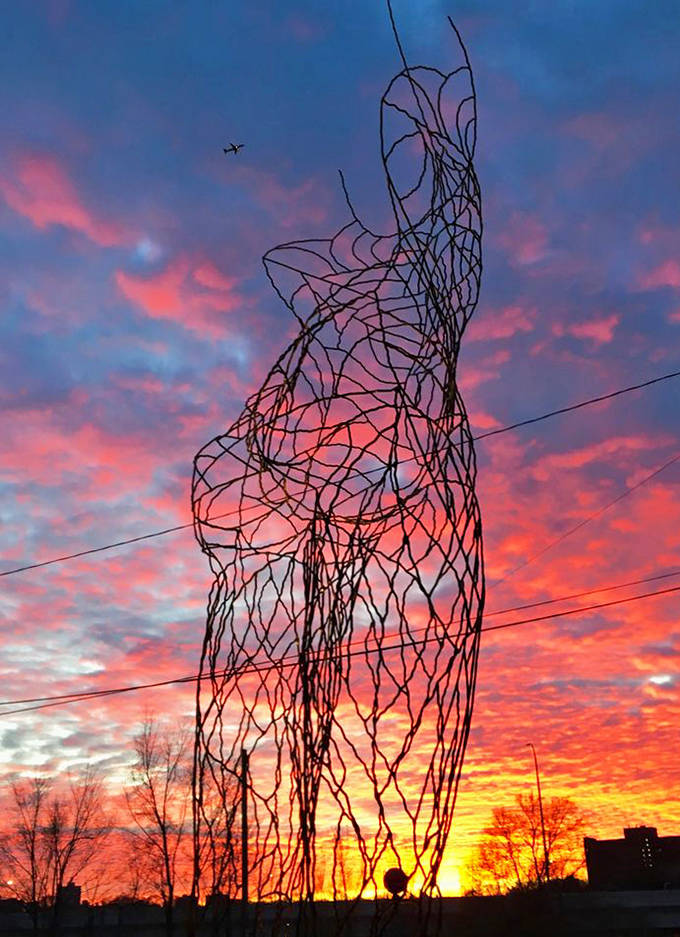The 19-foot tall wire figure stands as a neighborhood landmark, its human form reaching toward the heavens in a gesture of perpetual aspiration.