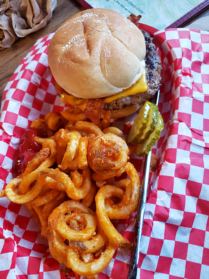 A bacon cheeseburger with curly fries that makes you question why anyone needs fancy food when this exists.