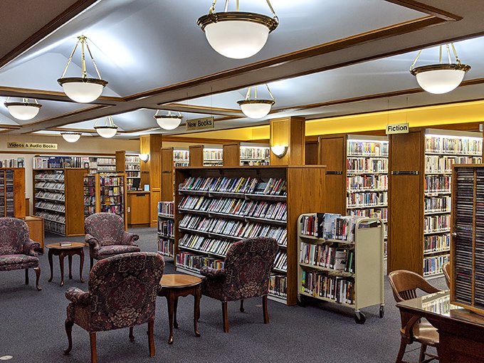 Comfortable reading nooks nestled among wooden shelving invite visitors to browse new releases or rediscover classics in this thoughtfully designed modern section.