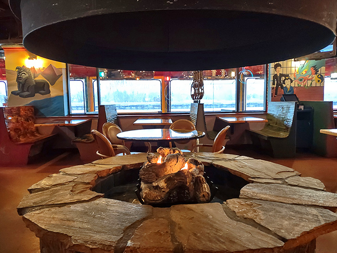 The central fire pit creates a primal dining experience – nothing pairs with seafood quite like the hypnotic dance of flames under a dramatic hood.