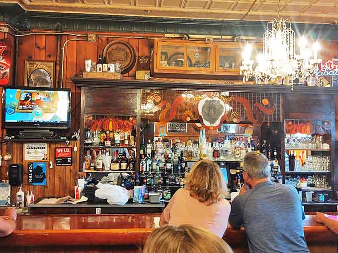 The well-stocked bar gleams under warm lighting, bottles standing at attention like soldiers ready to serve. Cocktails with no pretension, just proper pours.