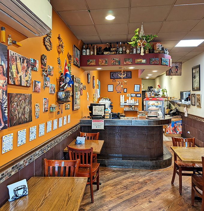 Vibrant orange walls adorned with Cuban art create a warm backdrop for the bustling heart of this neighborhood gem.