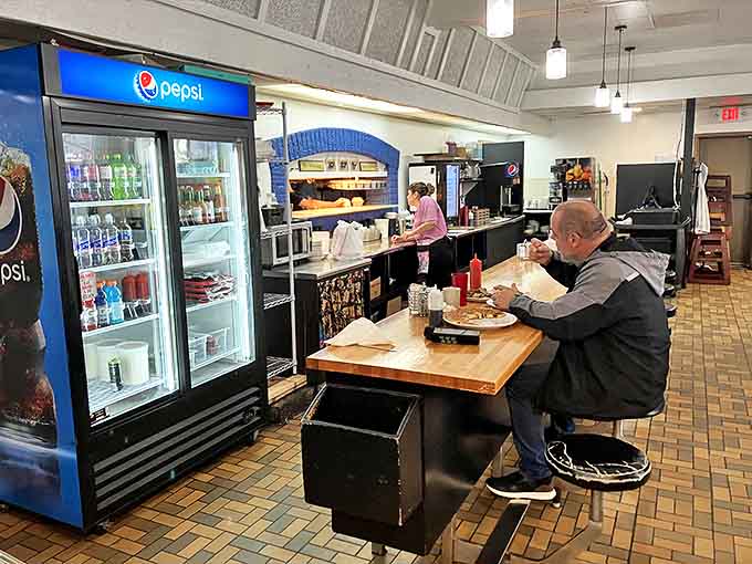The counter seating offers front-row tickets to the breakfast show, where regulars exchange stories over coffee while watching culinary magic unfold.