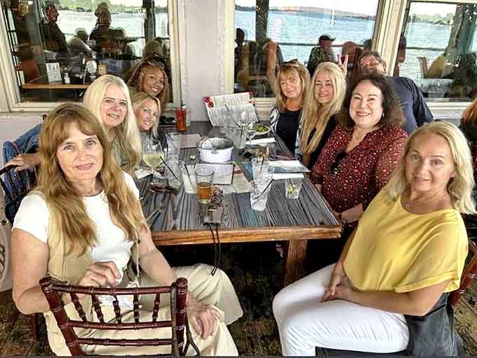 Happy diners gather at waterfront tables, where conversation flows as freely as the drinks and memories are made between bites of fresh seafood.