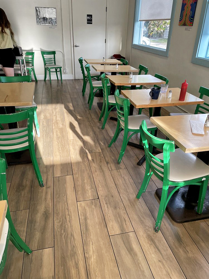 Green chairs add a pop of personality to this dining area, where breakfast dreams come true one table at a time.