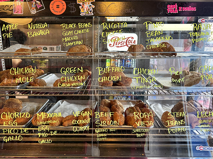 Decisions, decisions! The display case showcases today's empanada lineup, each handwritten label promising a different flavor journey.