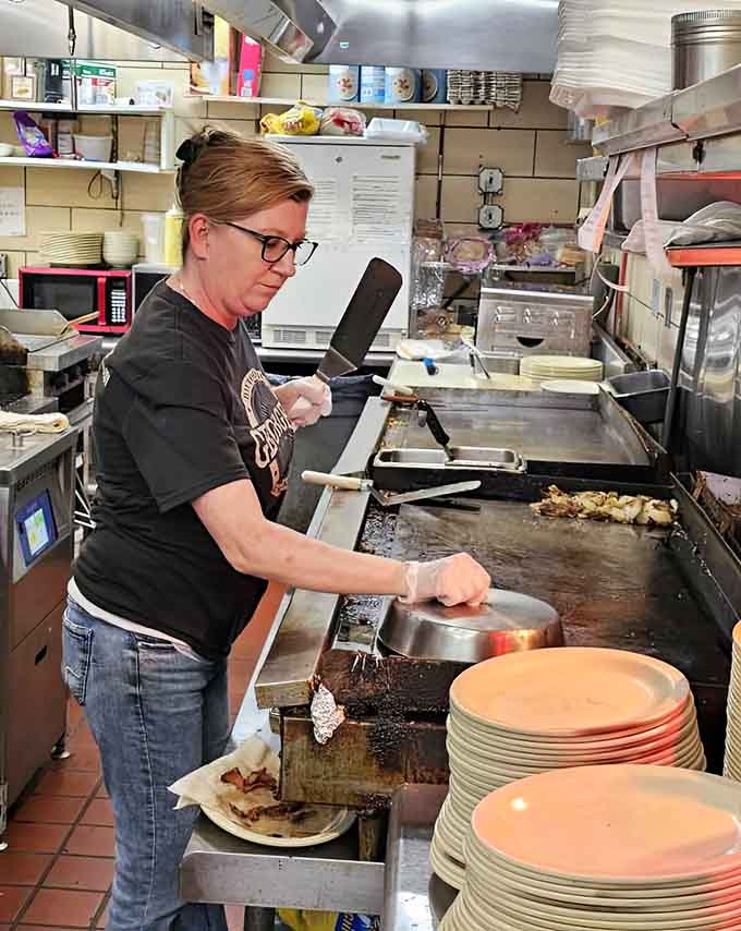 Behind the scenes, skilled hands work the griddle, transforming simple ingredients into the meals that keep customers coming back.