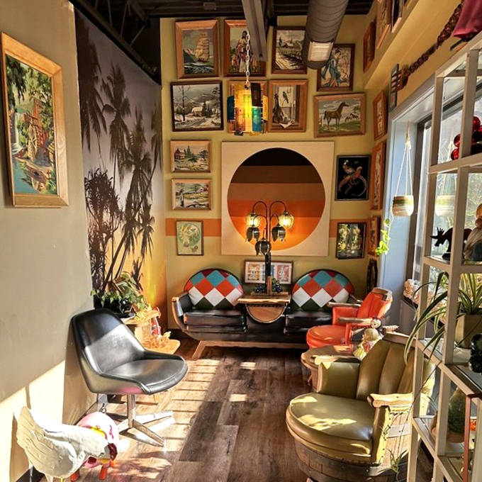 The waiting area feels like your coolest friend's living room. Those mid-century chairs and paint-by-numbers landscapes create a retro lounge worth the weekend wait.