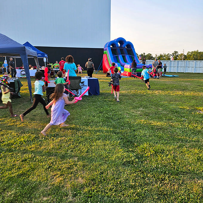 Children race across the grass as families set up chairs and blankets &ndash; the pre-movie playground buzz is half the fun of drive-in night.