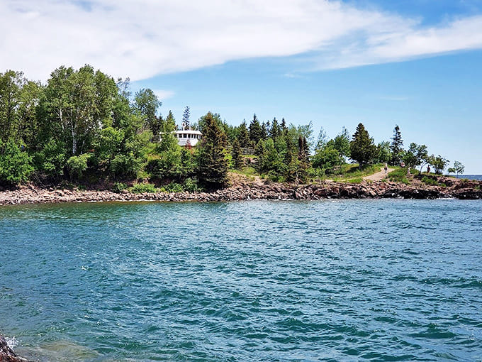 The rugged shoreline surrounding the lighthouse offers endless opportunities for contemplation as waves lap against ancient Lake Superior rocks.