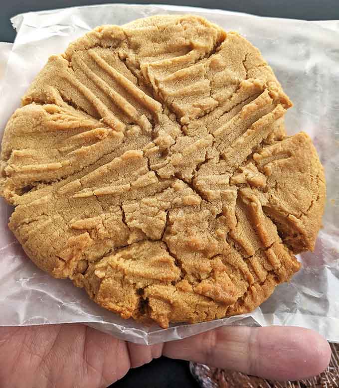 That thick peanut butter cookie with classic crosshatch marks signals serious cookie craftsmanship and zero compromises on size or flavor.