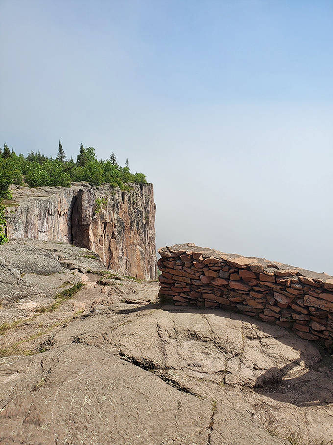 Morning mist creates a mysterious atmosphere where cliff meets sky, like standing at the edge of the world.