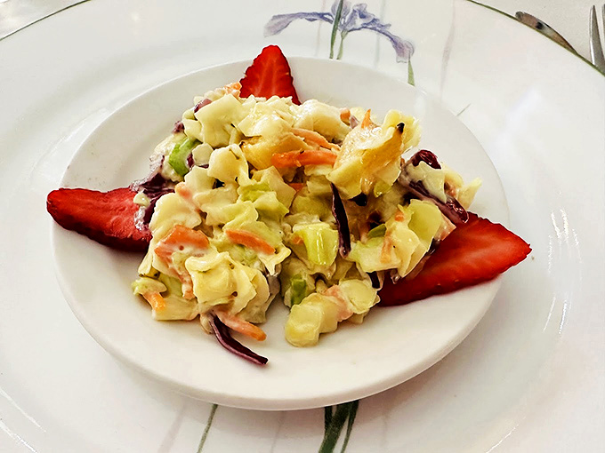 This summer coleslaw adorned with fresh strawberries demonstrates how simple ingredients become extraordinary with thoughtful preparation.