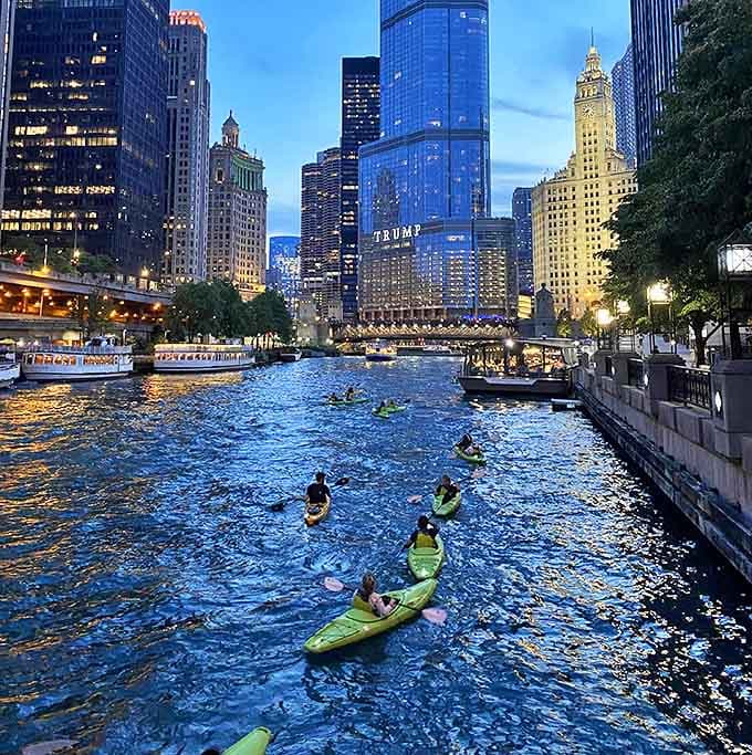 Evening brings out adventurous kayakers, paddling through the heart of downtown as city lights begin to twinkle against the deepening blue sky.