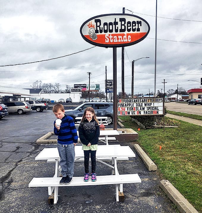Simple white picnic tables become prime real estate on summer evenings, hosting families and creating memories one root beer float at a time.
