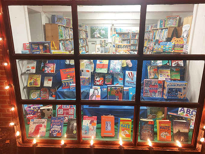 The children's section window glows with colorful covers and playful displays, creating a magical first impression for young readers.
