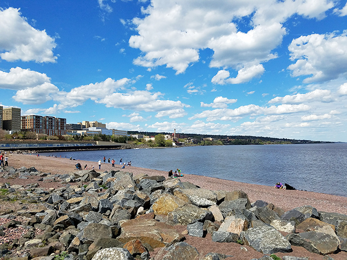Superior's rocky shoreline meets sandy beach, where brave souls dip toes into waters that redefine the concept of "refreshing."