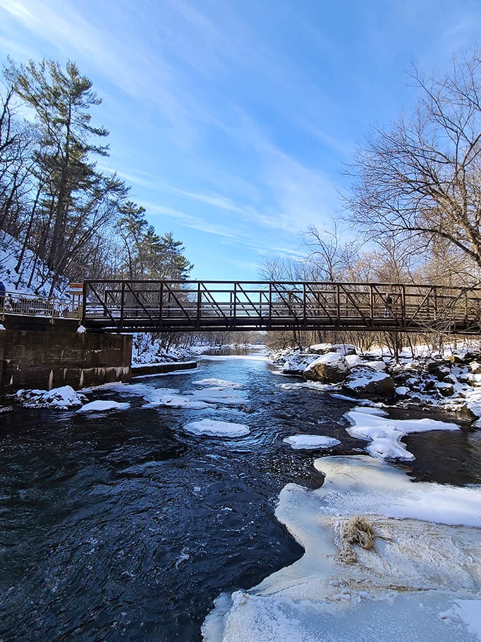 A sturdy footbridge spans the river, connecting trail systems while offering a perfect vantage point for spotting fish in the clear waters below.