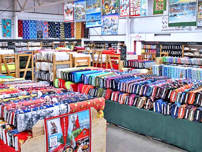 Fabric bolts arranged by color create an accidental rainbow that makes choosing just one nearly impossible.