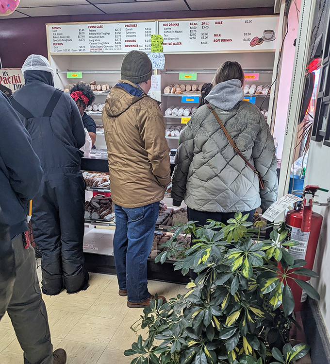 The morning rush creates a line of devoted followers, each customer practicing the ancient ritual of donut selection with reverent concentration.