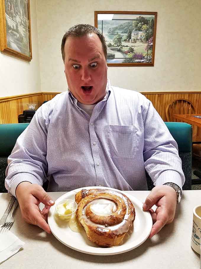 The look of pure joy when facing down a cinnamon roll the size of your head &ndash; breakfast bliss captured in one expression.