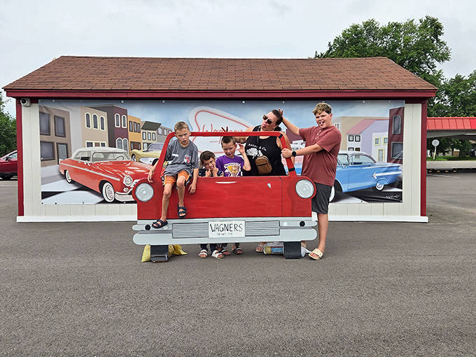The vintage car mural provides the perfect photo opportunity, where families create memories against a backdrop celebrating America's automotive golden age.