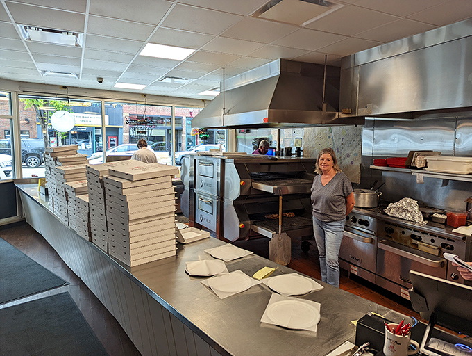 The choreographed dance of pizza-making, where modern efficiency meets techniques that have stood the test of time.