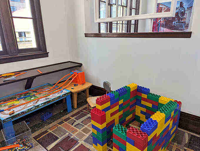Even building blocks get the railroad treatment, with oversized LEGO-style bricks creating a colorful fort where imagination makes all the stops.