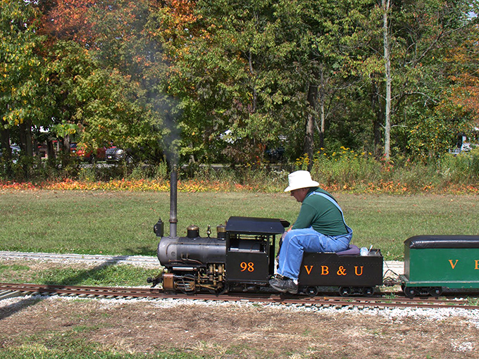 Craftsmanship meets joy as this engineer navigates his miniature steam locomotive with the precision of a maestro conducting.