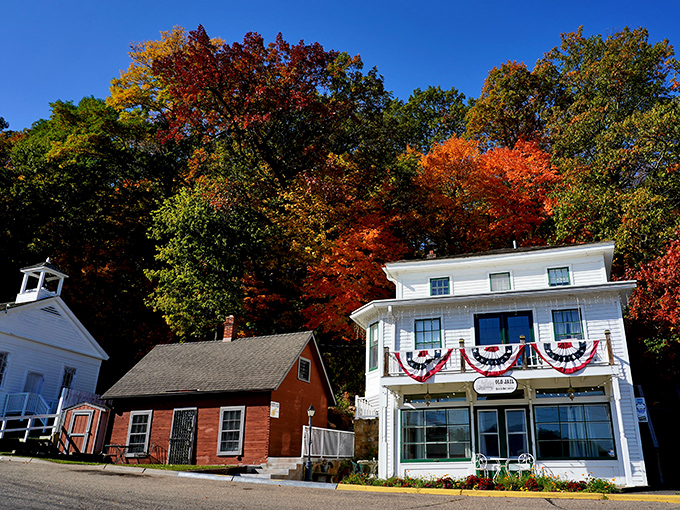 Historic buildings draped in patriotic bunting stand as colorful sentinels against autumn's spectacular backdrop in downtown Taylors Falls.