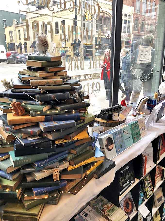 A Christmas tree made entirely of books stands in the window display, proving that literature can be both metaphorically and literally uplifting.