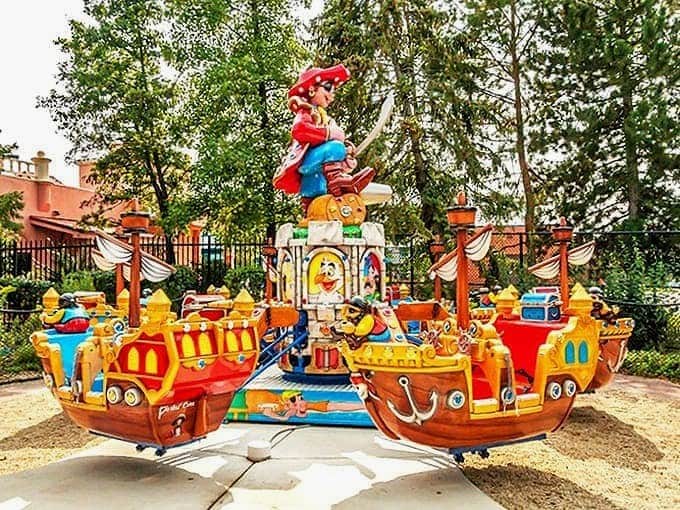 Colorful pirate ships spin with glee, captained by children whose laughter rings out louder than any ship's bell could.