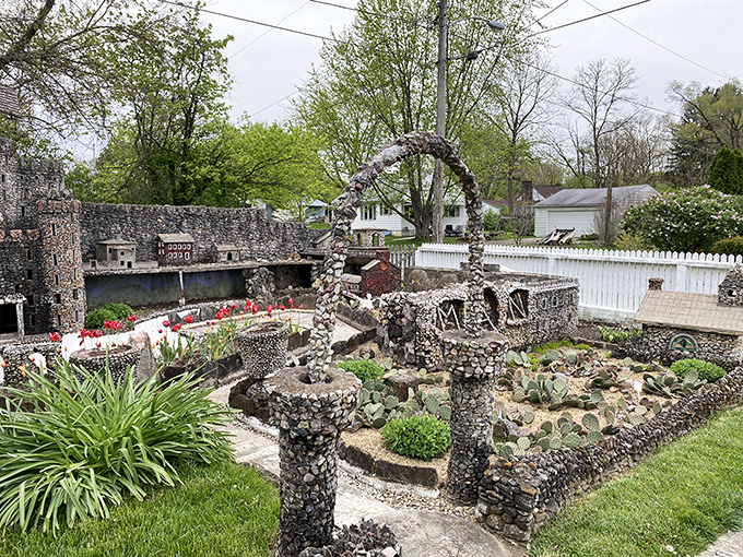 A perfectly proportioned stone archway frames the garden path, inviting visitors to continue their journey through this handcrafted wonderland.