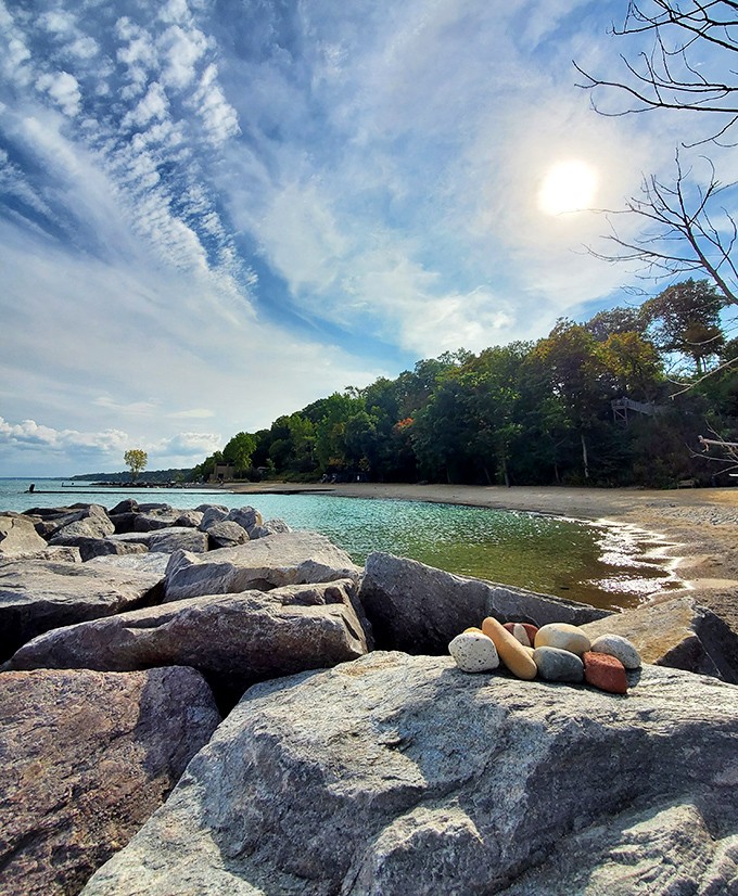Carefully balanced stones create impromptu sculptures along the rocky shoreline, evidence of visitors finding moments of zen amid natural beauty. Rock art that rocks!
