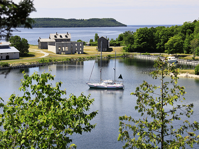 A sailboat glides into Snail Shell Harbor, approaching the historic townsite just as supply vessels did during Fayette's industrial heyday.