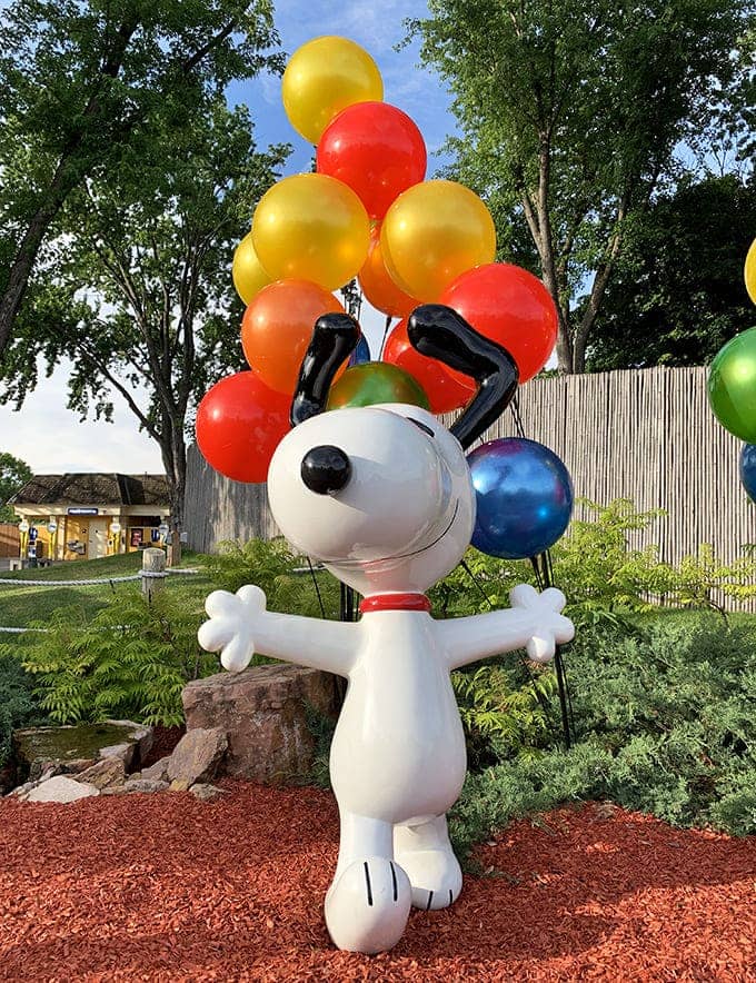 Snoopy: The world's most famous beagle welcomes visitors with balloon-backed enthusiasm, standing as the unofficial ambassador of childhood joy.