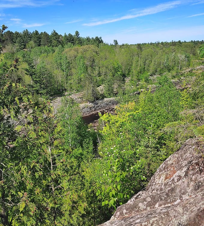 Rocky outcroppings provide natural overlooks where hikers can pause to appreciate the vast forested landscape.
