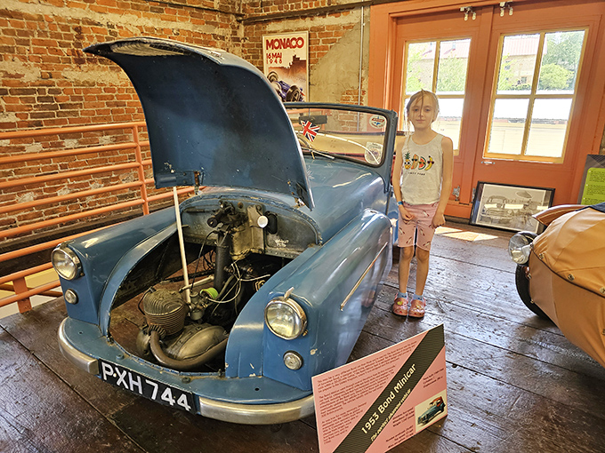 This blue British microcar with its hood proudly open reveals surprisingly simple mechanics &ndash; proving great adventures sometimes come with very small engines and even smaller legroom.