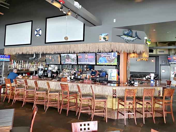 The thatched-roof tiki bar serves as command central for tropical libations, where bartenders craft everything from classic mai tais to creative Michigan-inspired cocktails.