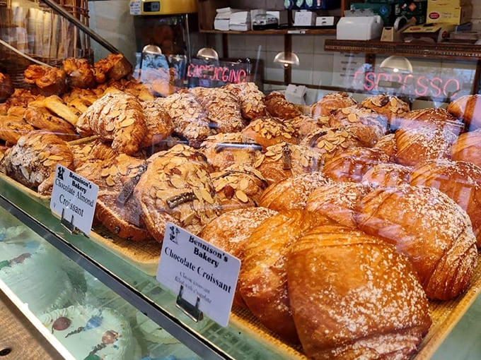 Golden croissants bask in their display case glory, their honeycomb interiors promising that satisfying shatter with every perfect bite.