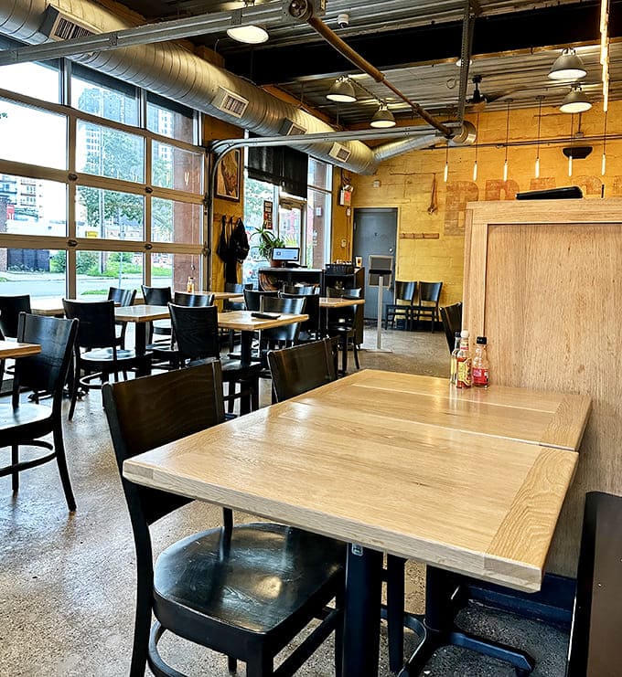 Wooden tables bathed in natural light create an atmosphere where time slows down and conversations flow as freely as the drinks.