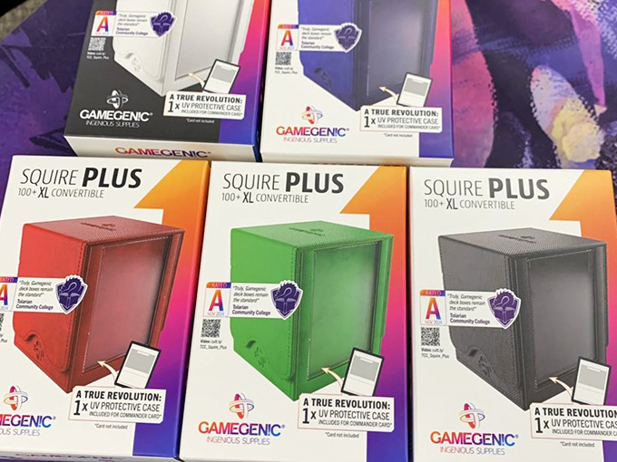 Colorful deck boxes stand ready to protect precious card collections, the gaming equivalent of luxury condos for cardboard treasures.