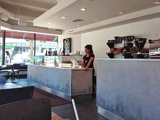 The welcoming counter area showcases the cafe's commitment to local craftsmanship with its handmade wooden details and warm lighting.