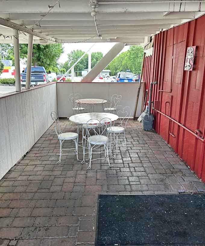 White wrought-iron patio furniture on brick pavers offers a charming spot to enjoy your meal while pretending you're in a Norman Rockwell painting.